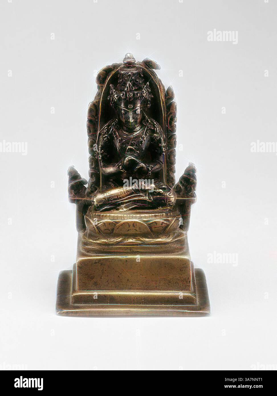 A finely detailed statue of a seated deity, adorned with intricate ...
