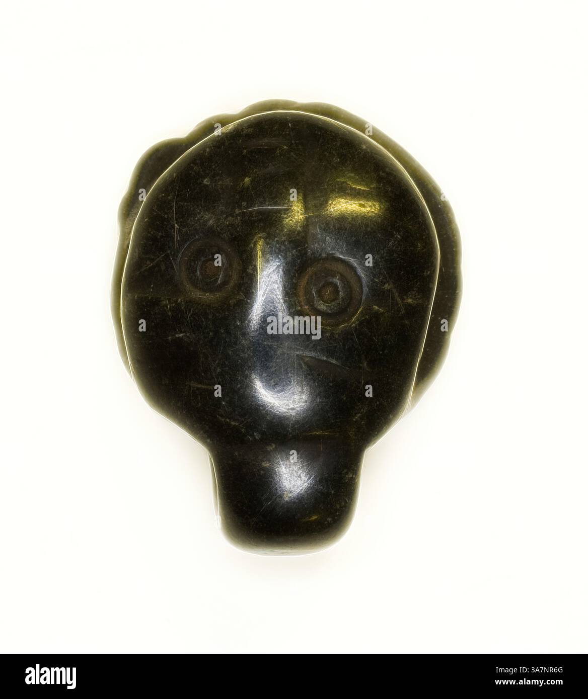 A carved stone depiction of a human face, featuring distinct facial ...