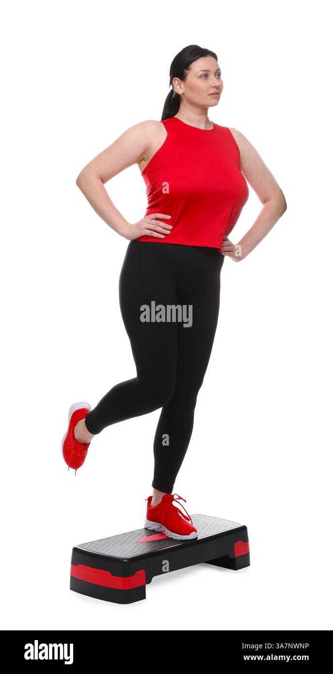 Plus size woman in gym clothes doing exercise with step platform on ...