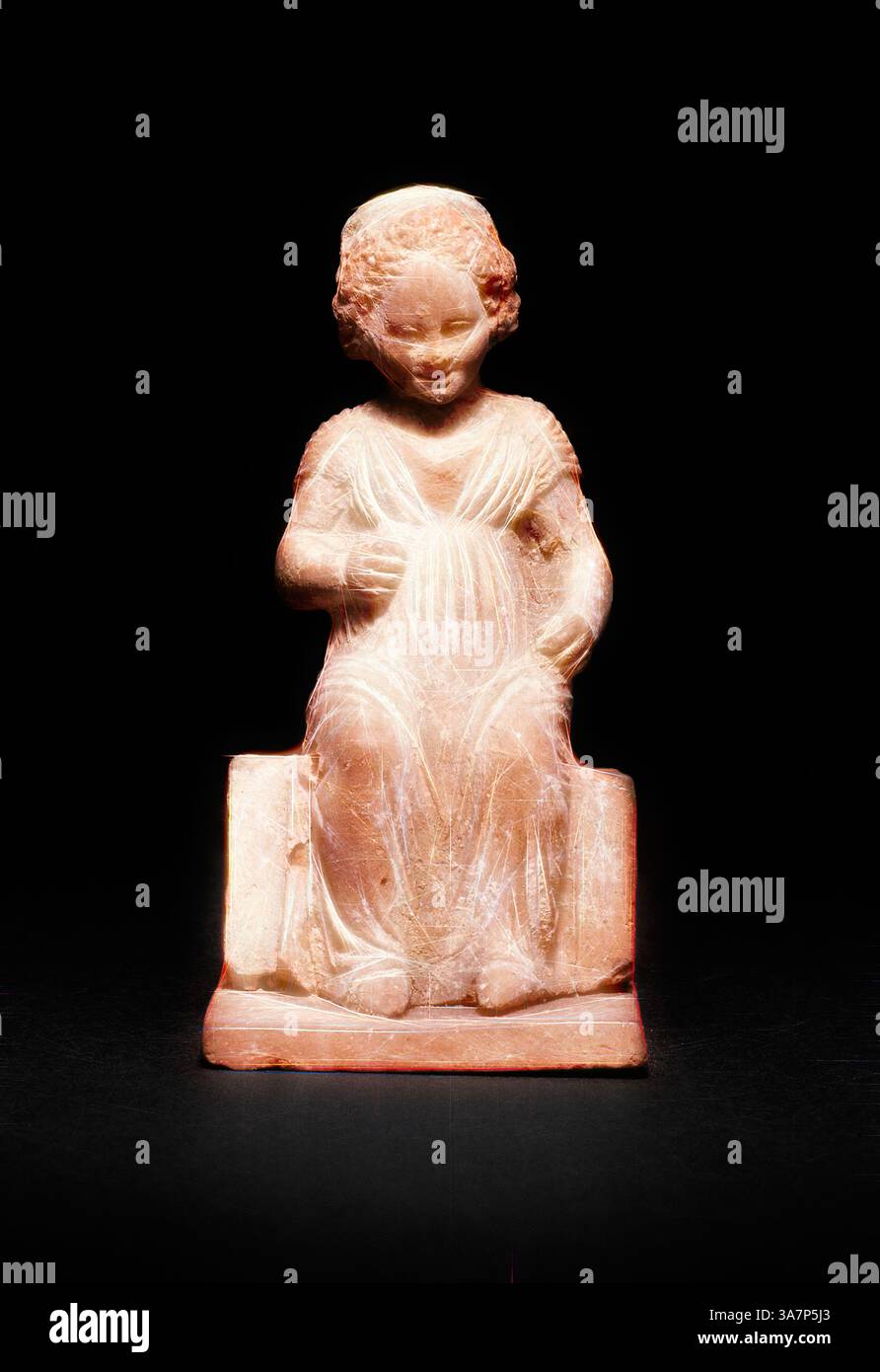A small statue of a seated figure, depicted in a classic pose, with a ...