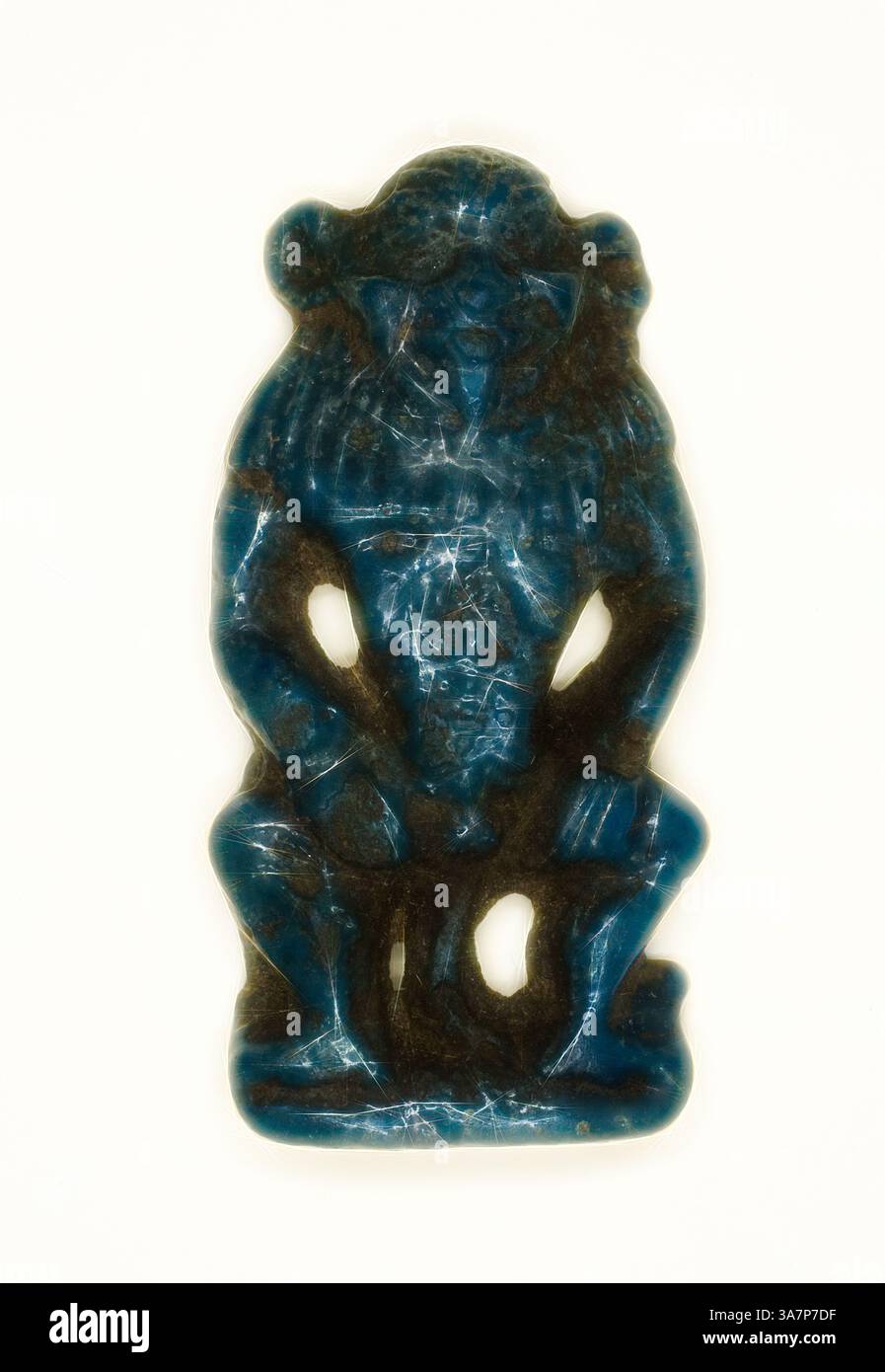 A blue stone carving of a seated figure resembling a lion, with ...