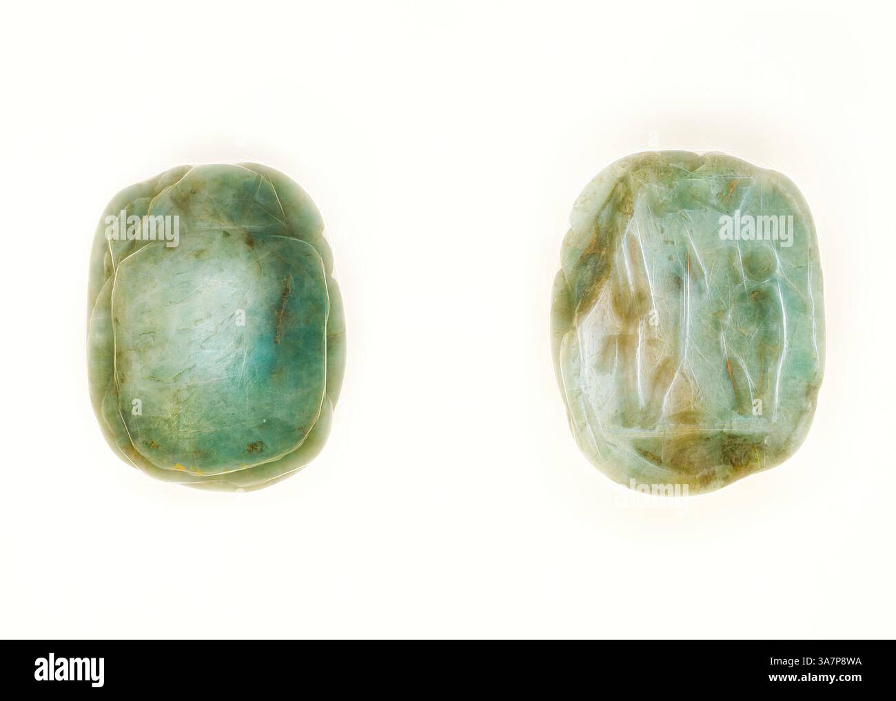 Two intricately carved jadeite stones, one featuring a smooth, polished ...