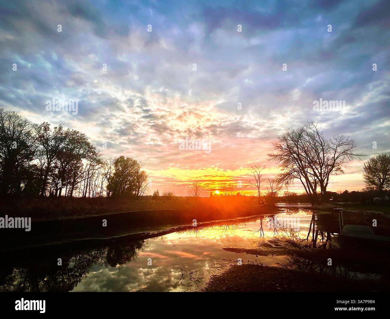 Vibrant Sunset over Lake with Sky's Reflection in Water Stock Photo - Alamy