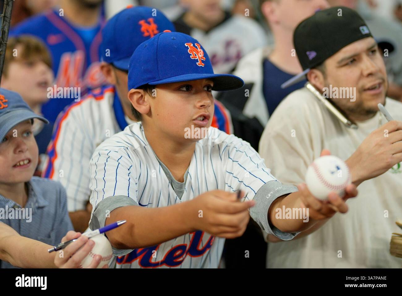 Cruz Perez reaches to get an autograph before an opening-day baseball ...