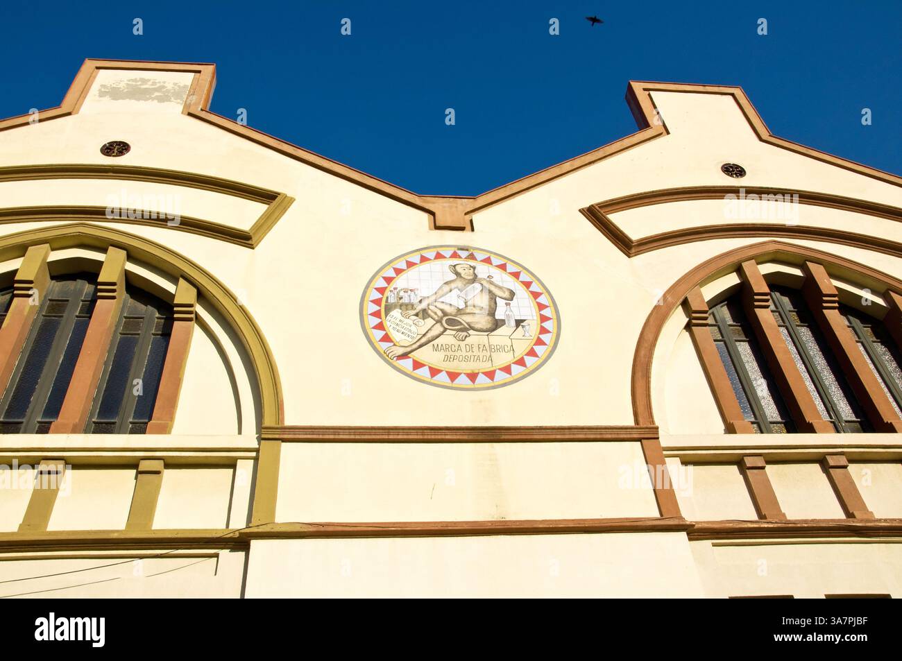 Main front of the Factory Anís del Mono with the famous logotype of a ...