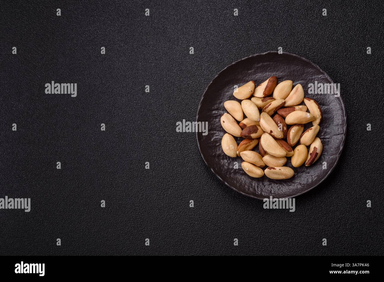 Brazil nut kernels in ceramic bowl on dark concrete background Stock ...