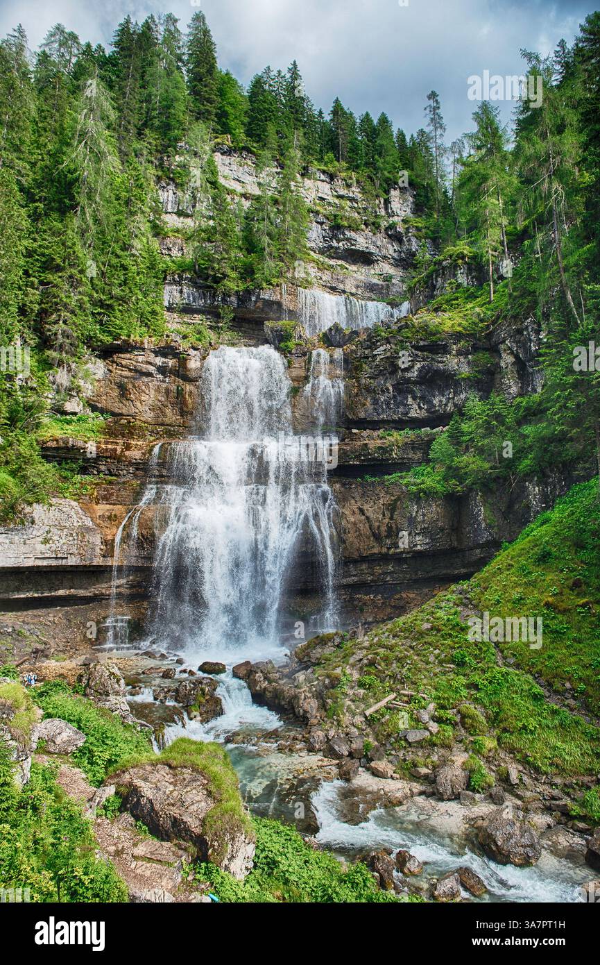 Water is cascading down the rocky mountainside at Vallesinella Falls in ...