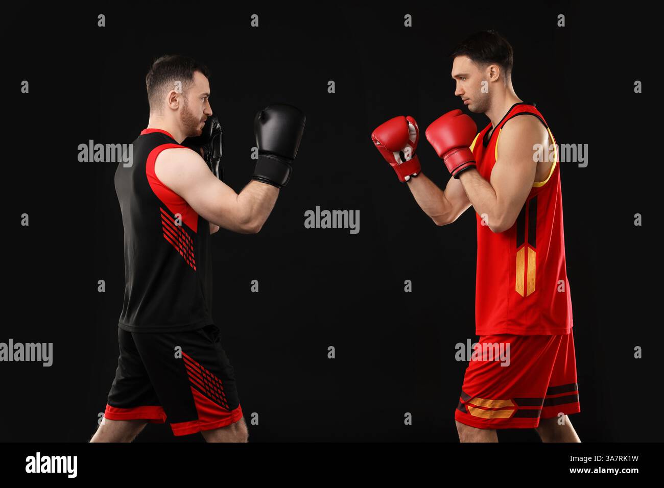 Men in boxing gloves fighting on black background Stock Photo - Alamy