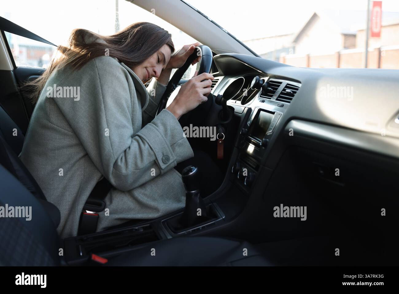 Tired driver sleeping on steering wheel in car Stock Photo - Alamy