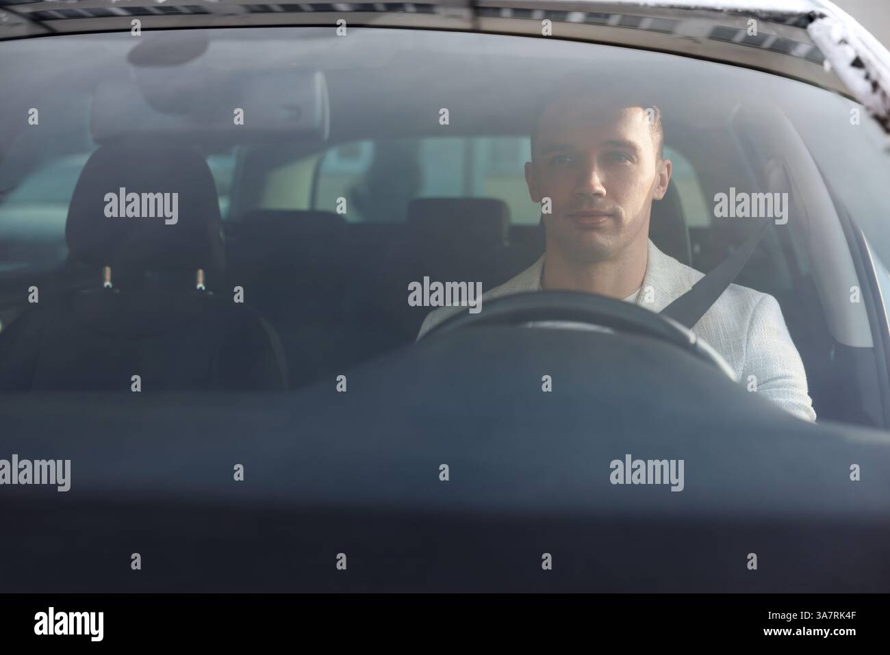 Driver behind steering wheel of modern car, view from windshield Stock ...