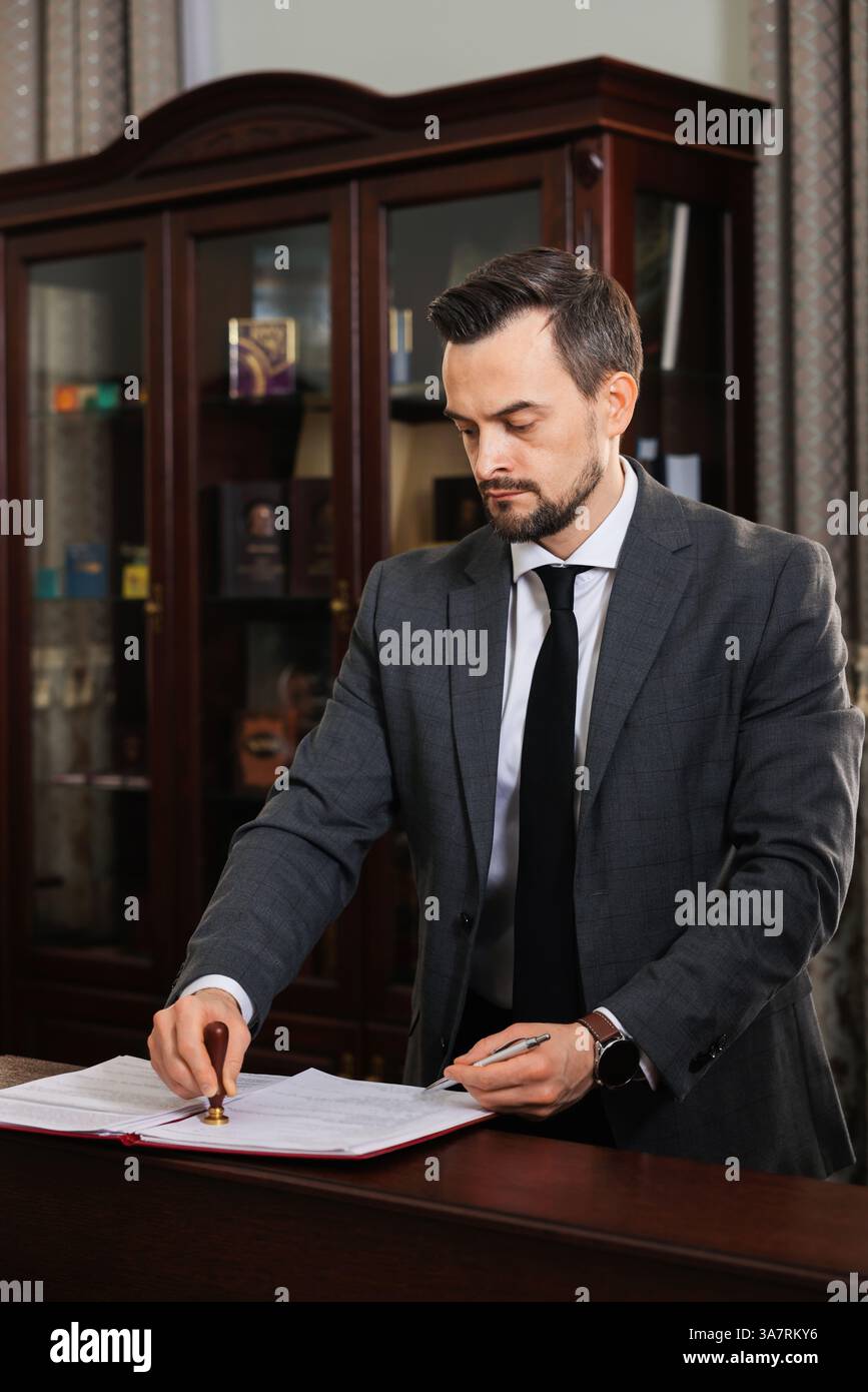 Notary stamping document at counter in office Stock Photo - Alamy