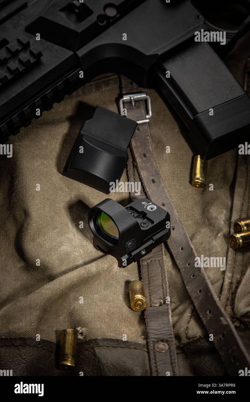 A tactical setup featuring a firearm, red dot sight, and ammunition on ...