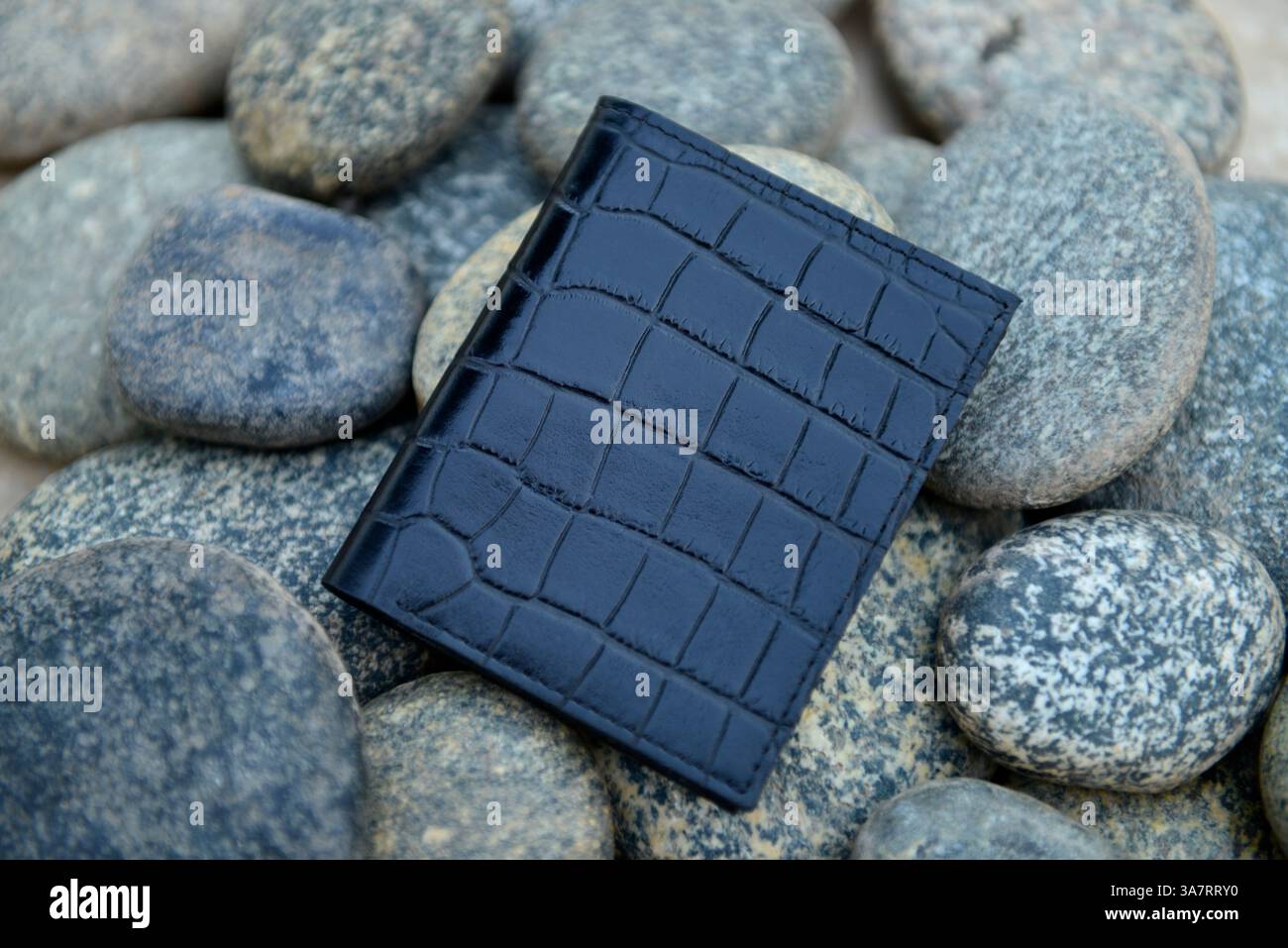 A black leather wallet for men, placed on stones Stock Photo - Alamy
