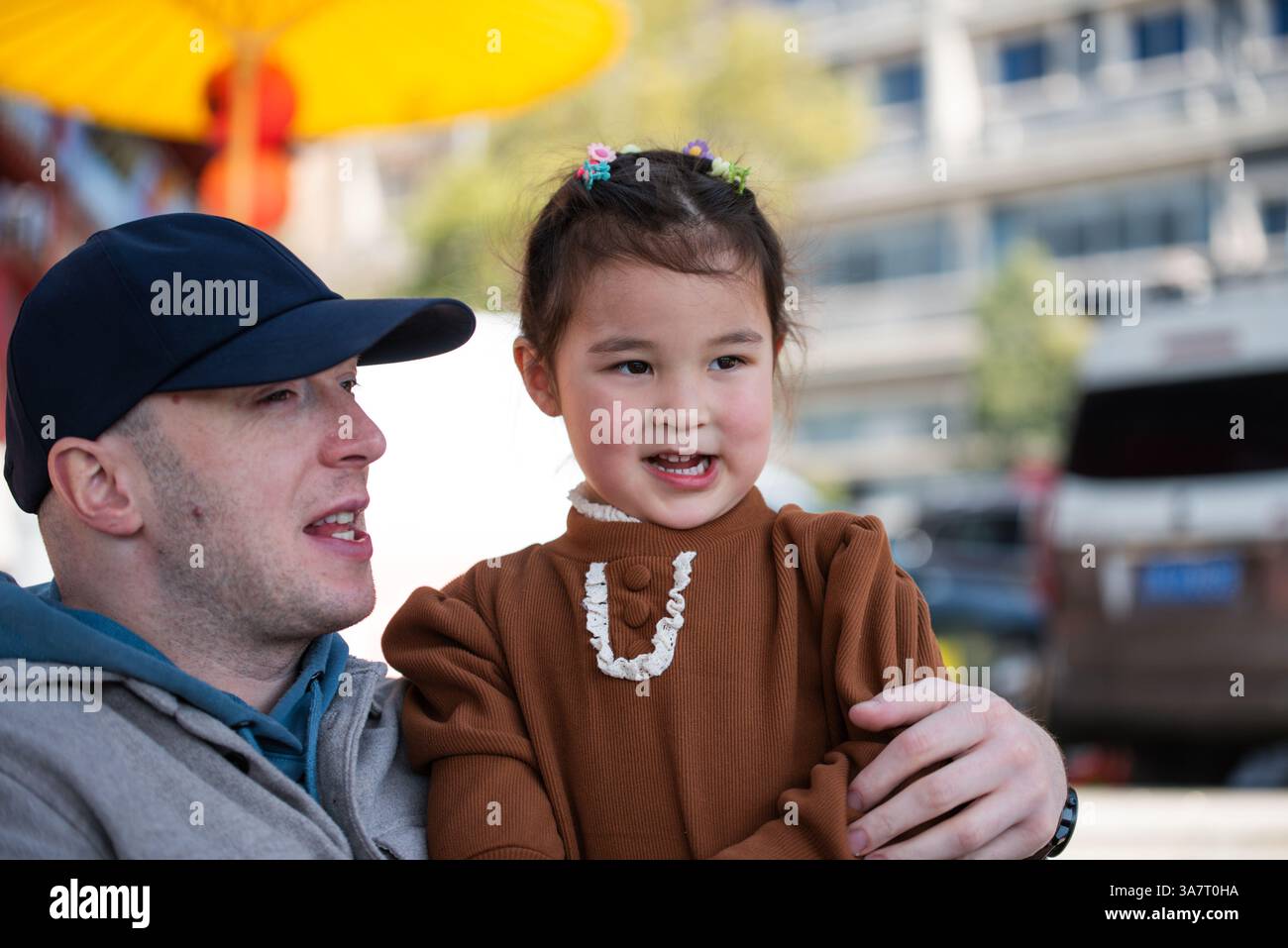 Happy beautiful multiracial girl and her father hugging during the rest ...