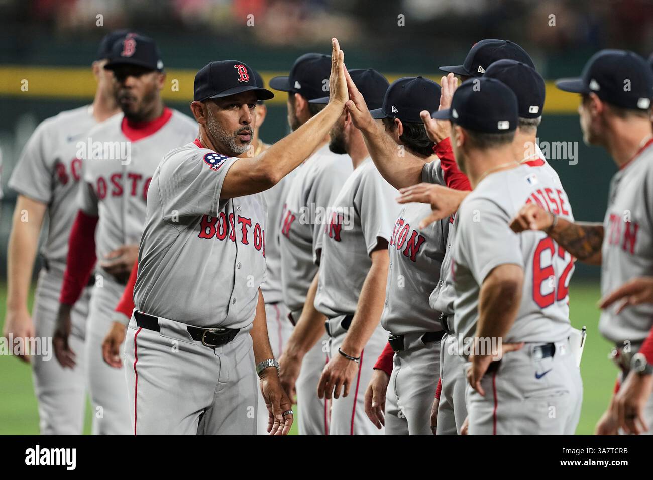 Boston Red Sox manager Alex Cora, left, is greeted by his team during ...