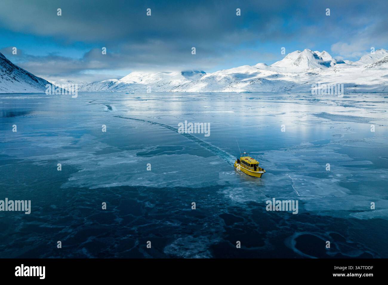 A boat travels though a frozen sea inlet outside in Nuuk, Greenland ...