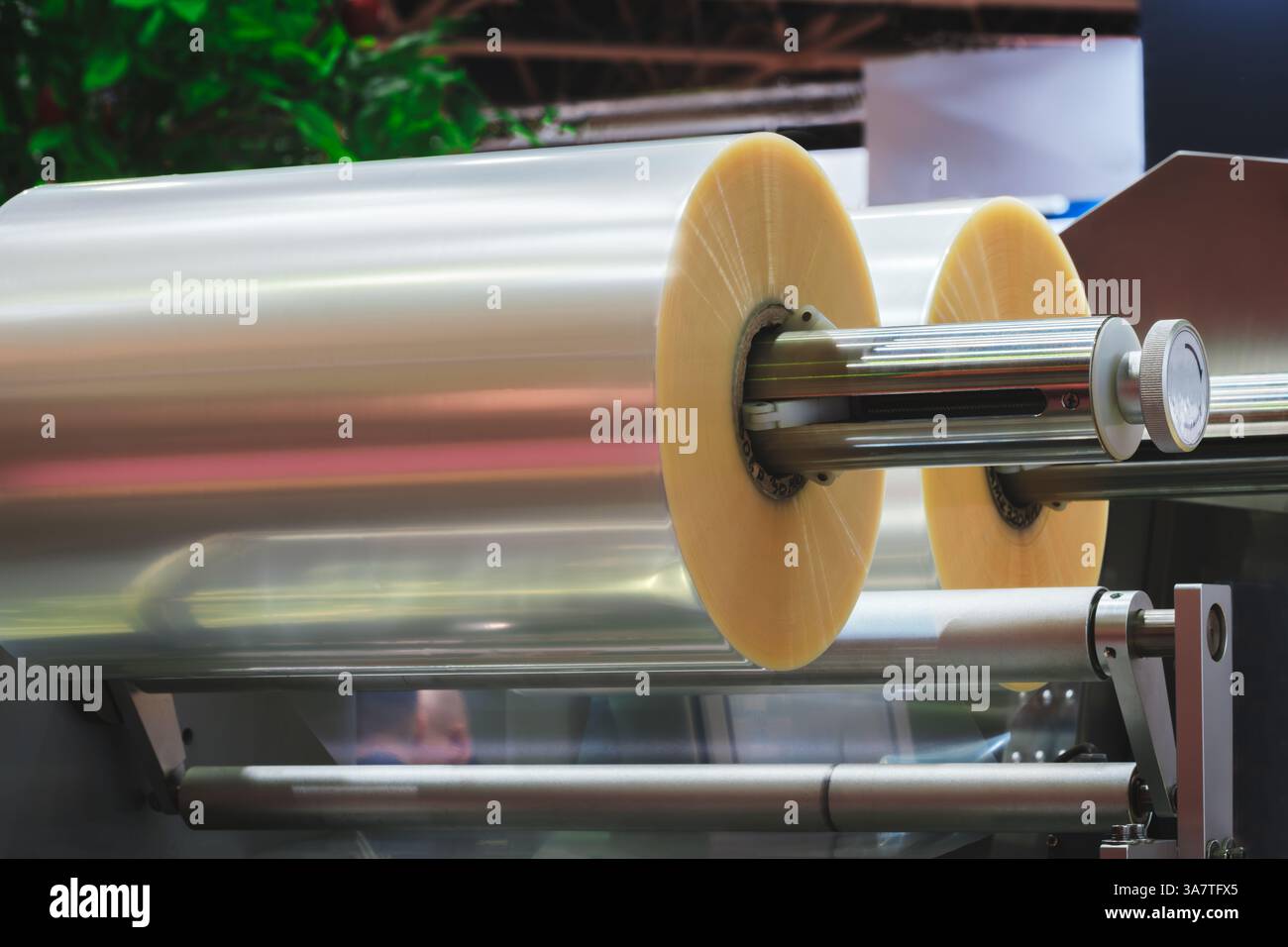 A machine with a roll of polyethylene plastic film on it. The machine ...