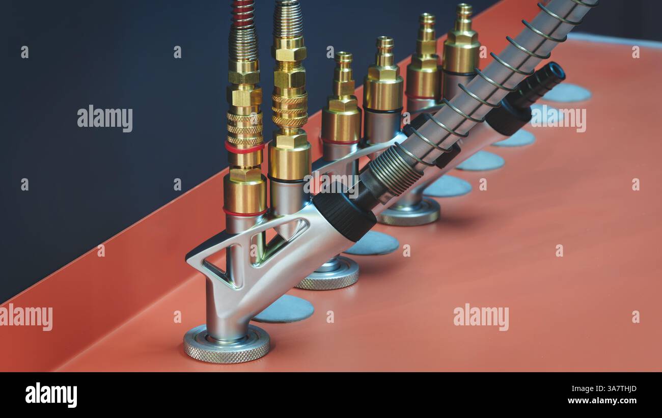 A row of metal tubes with a silver nozzle on top. The tubes are ...