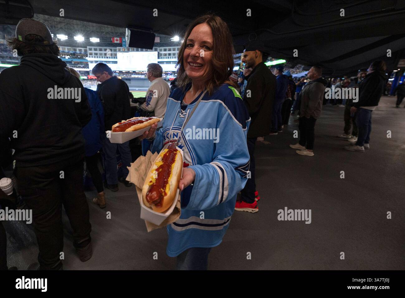 Dana poses with two footlong hotdogs ahead of the Toronto Blue Jays ...