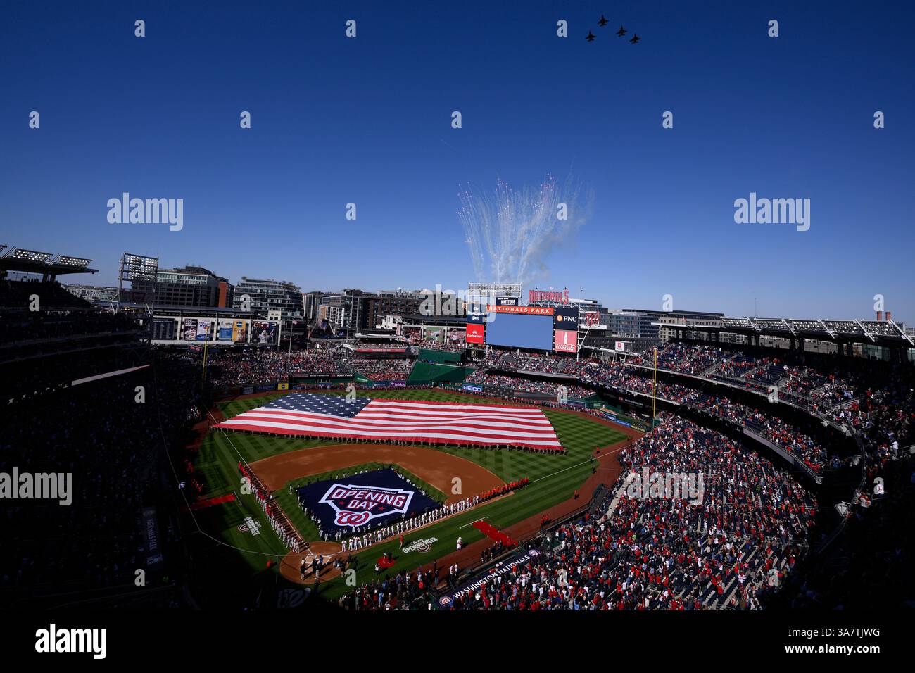 An American flag is displayed on the field along with a flyover before ...