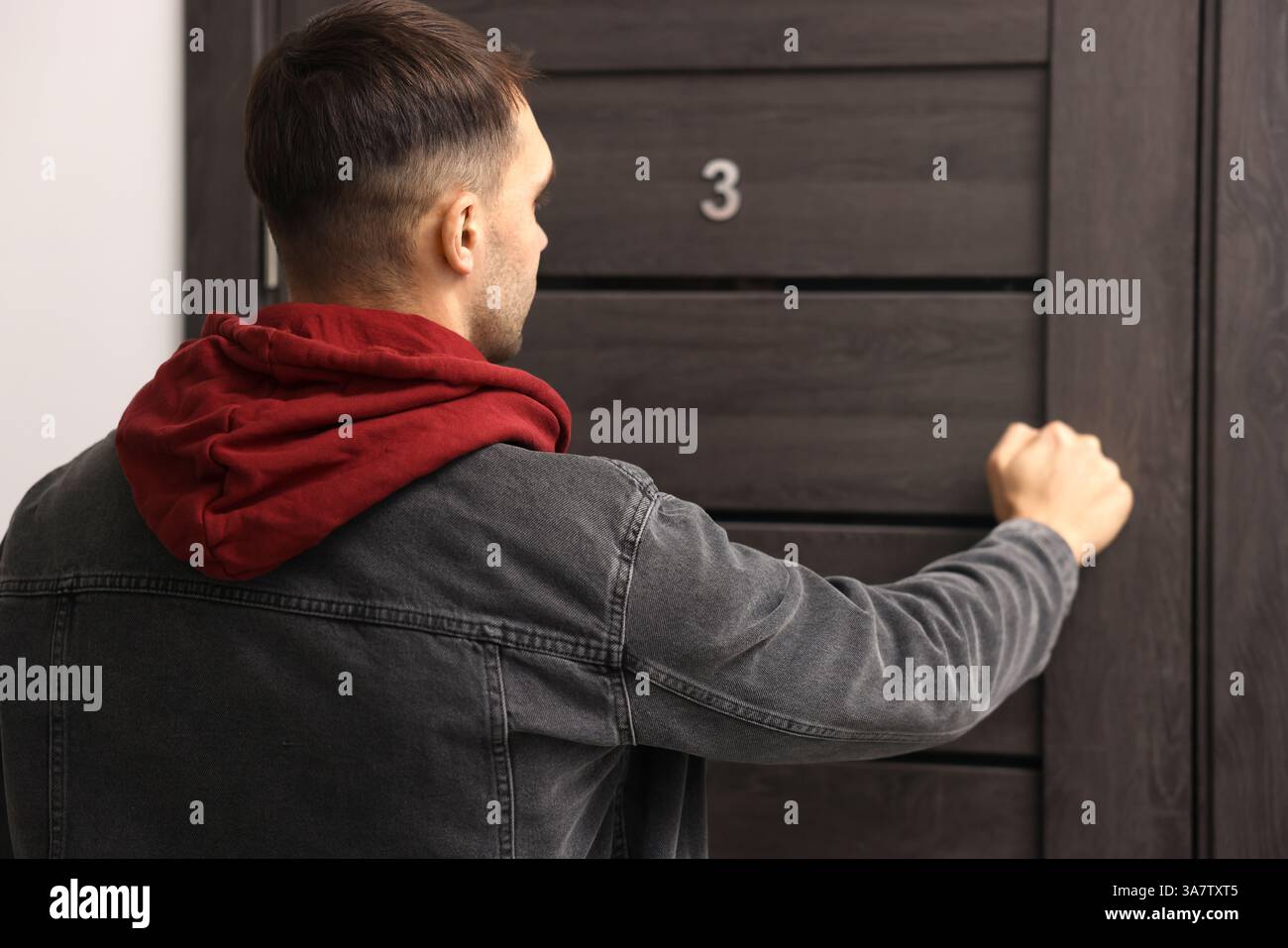 Man knocking on door of his friends apartment Stock Photo - Alamy