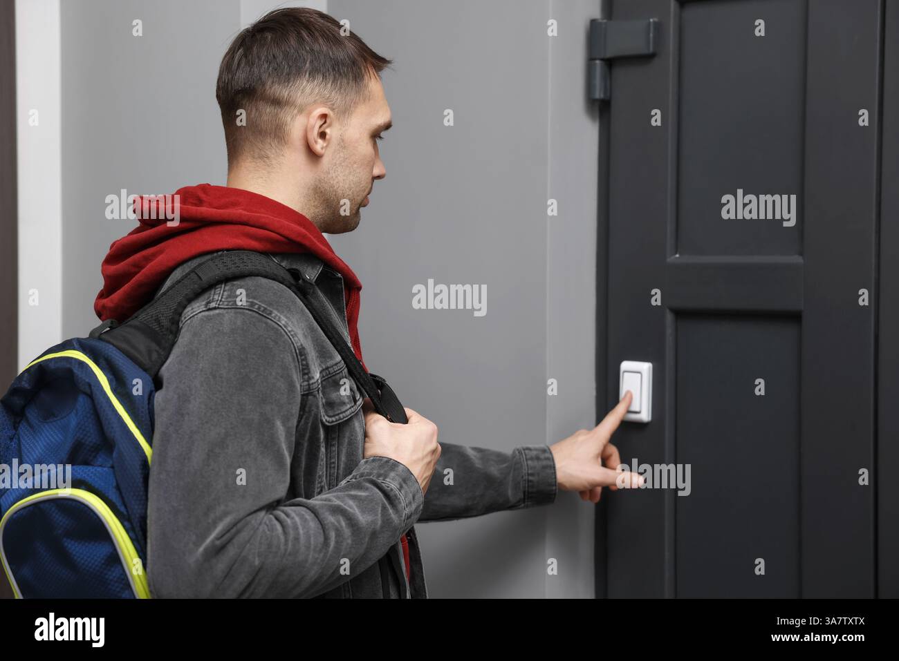 Man ringing doorbell of his friends apartment Stock Photo - Alamy