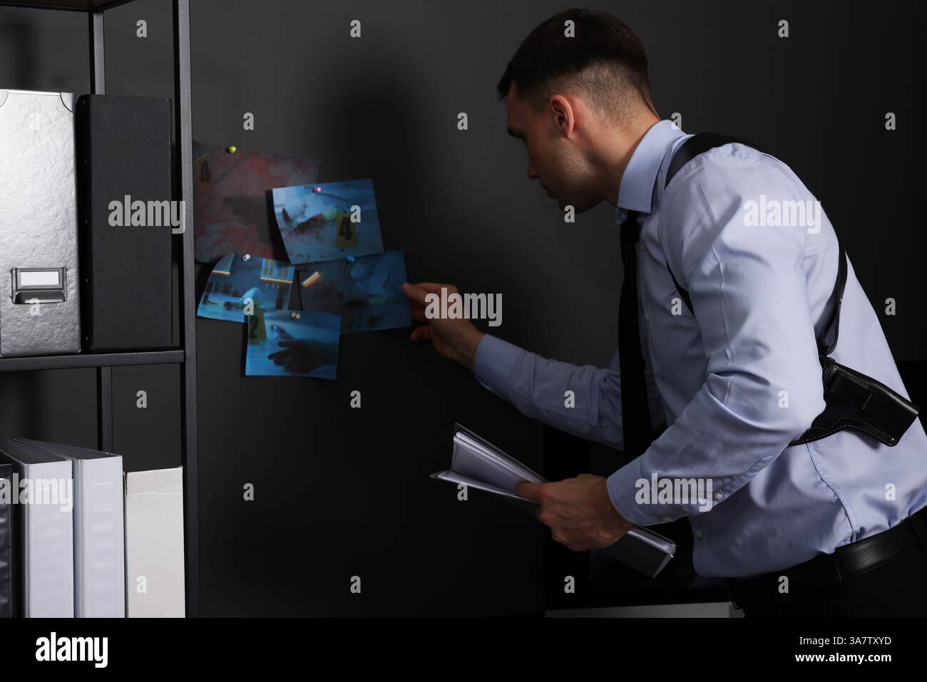 Forensic expert working with crime scene photos in office Stock Photo ...