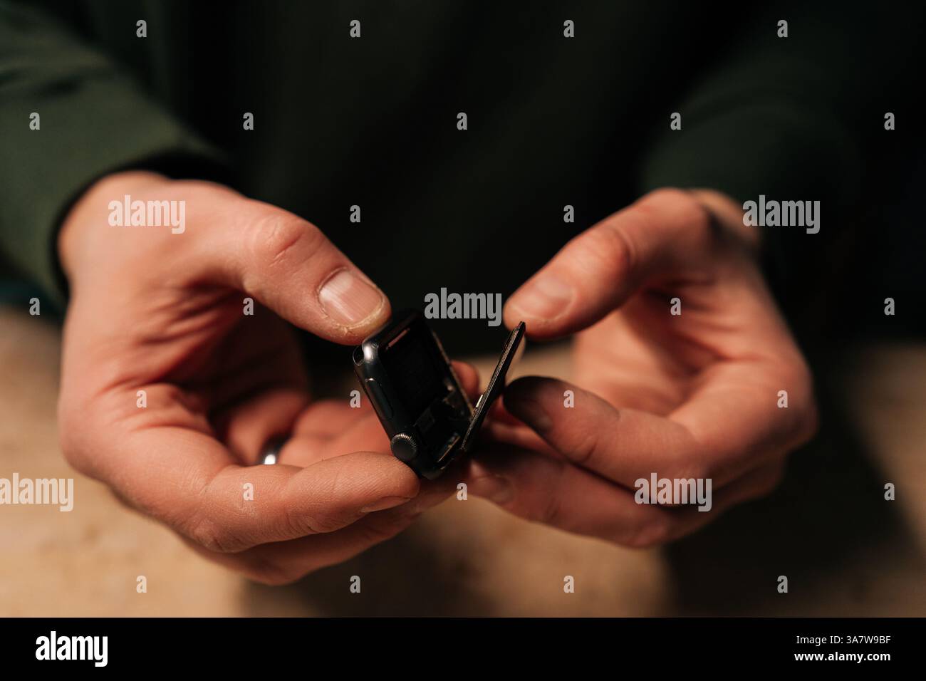 Professional technician male carefully opening smartwatch to replace ...