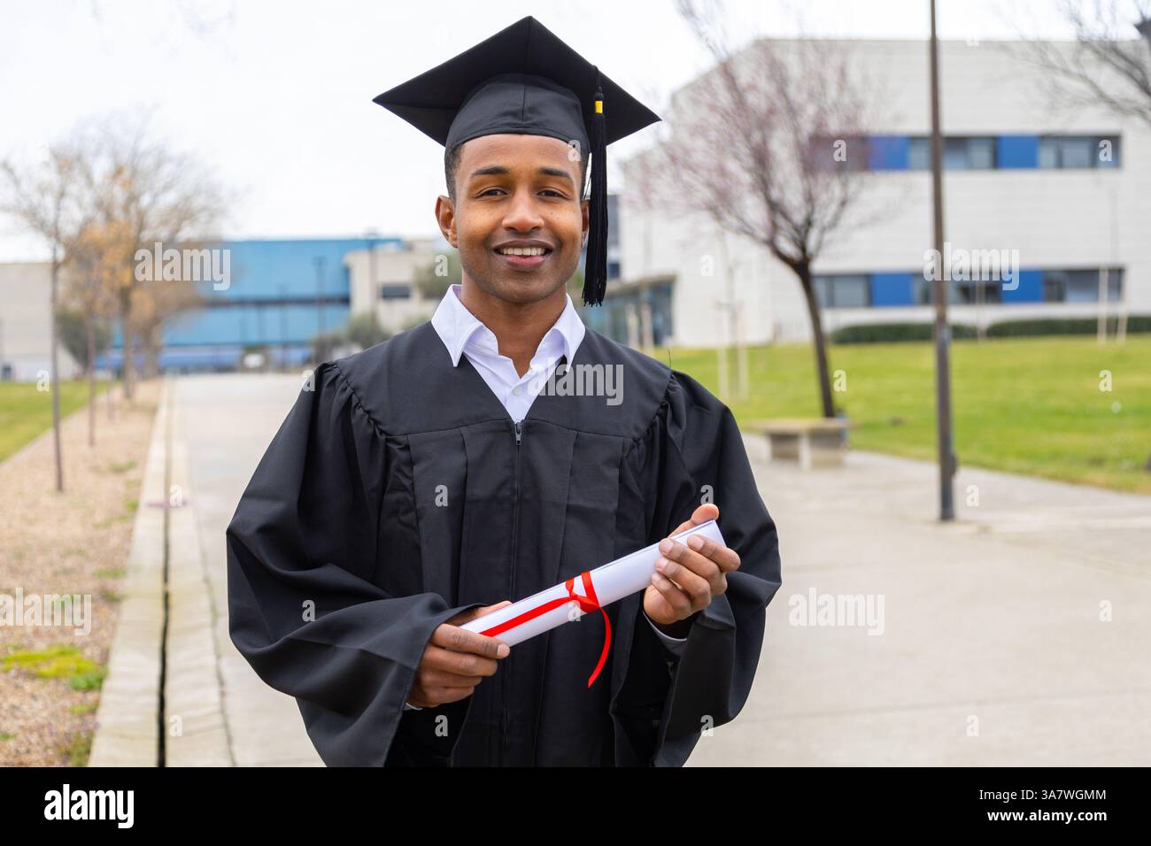 Smiling african american graduate student wearing graduation gown and ...