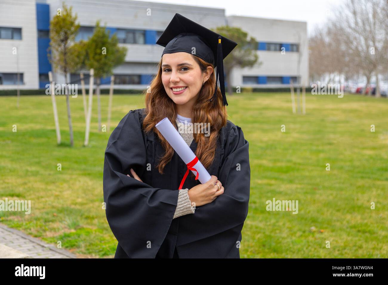Portrait of a young woman celebrating her graduation holding her ...