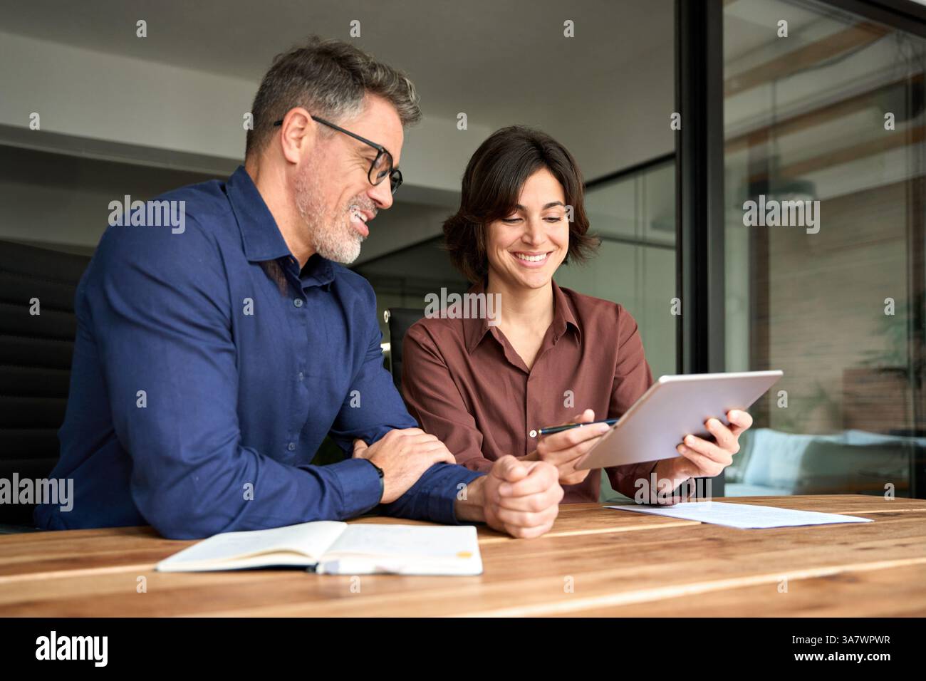 Two happy business colleagues having conversation at office meeting ...