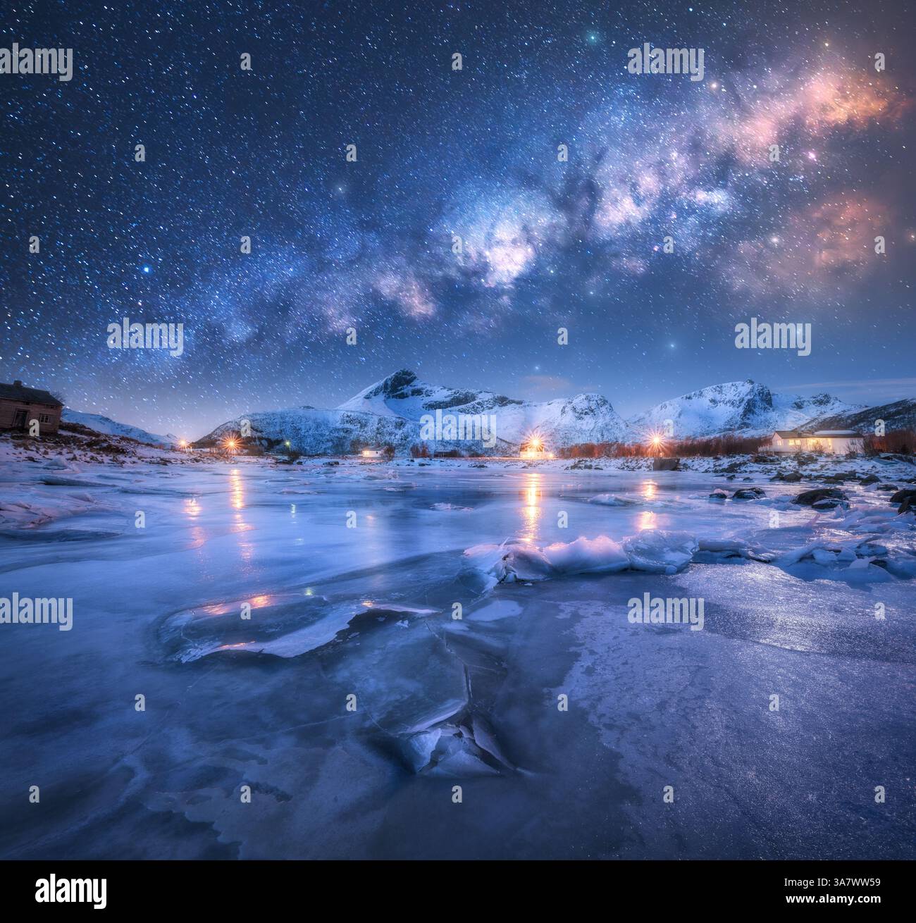 Milky Way arch above fjord and snowy mountains on starry winter night ...