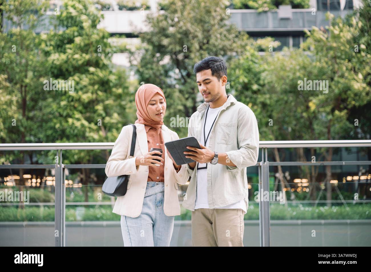 Two young professionals are discussing business strategy using a ...