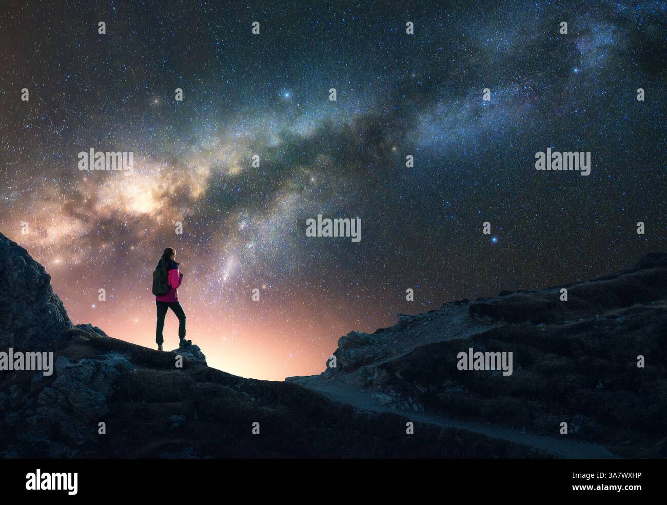 Glowing Milky Way and woman on mountain peak at starry night. Dolomites ...