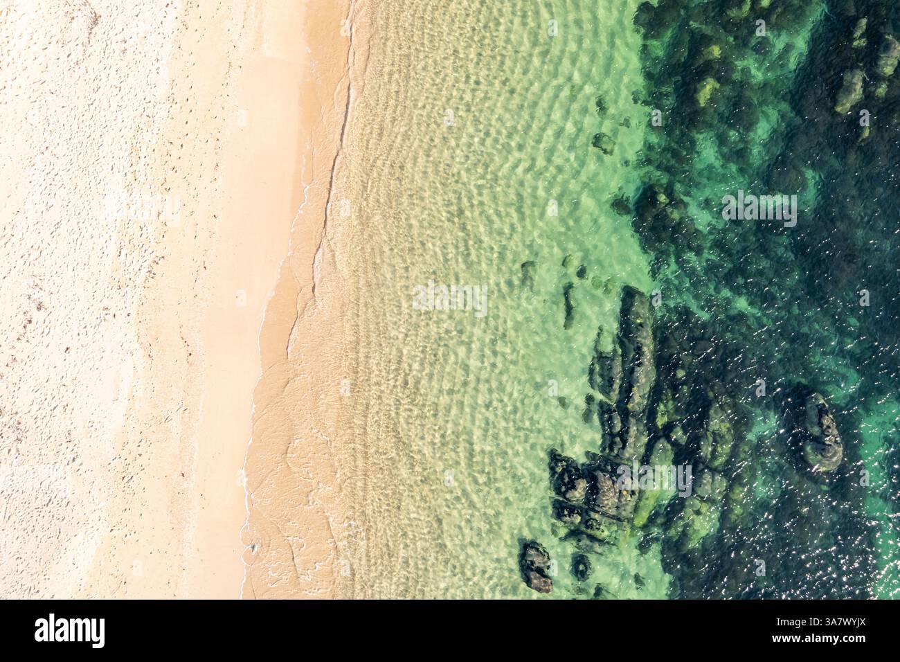 beach textures of sand, water, and rocks from above. Aerial drone top ...