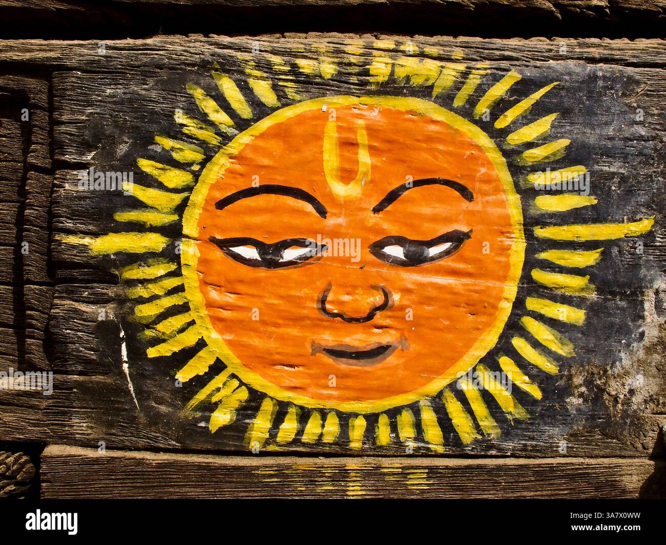 Hand-painted sun face on temple woodwork in Patan, Nepal, symbolising ...