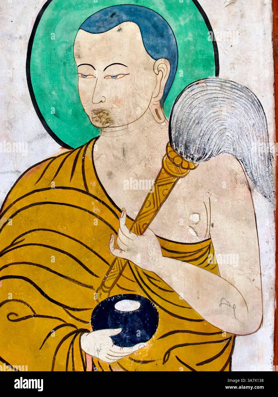 Wall painting of a Buddhist monk holding a fly whisk and alms bowl at a ...