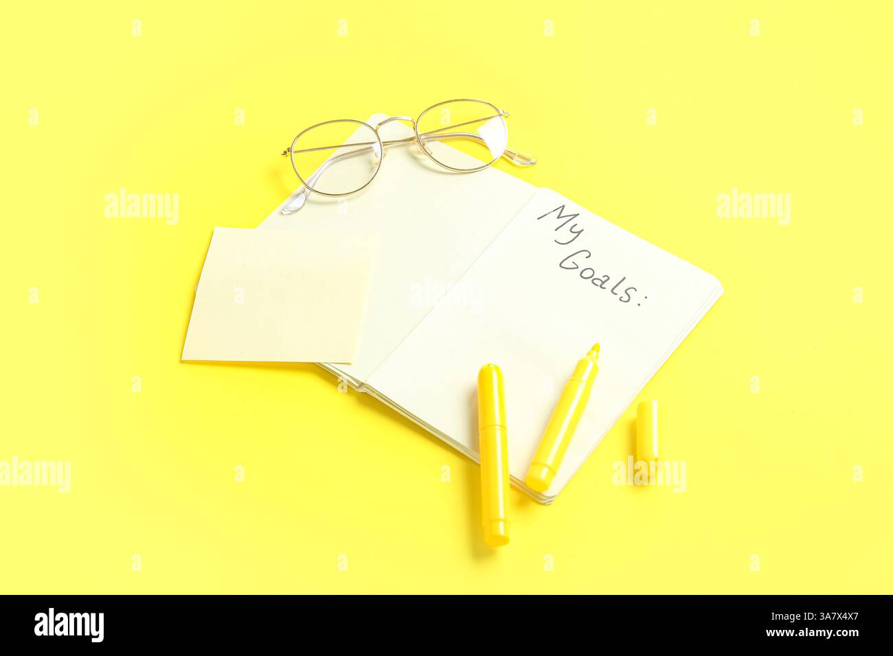 Notebook with empty to do list, markers and eyeglasses on yellow ...