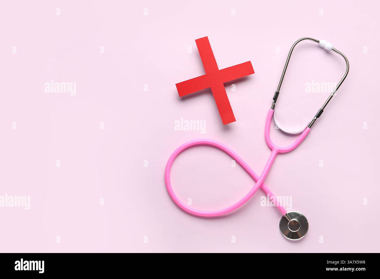 Stethoscope and red cross on pink background Stock Photo - Alamy