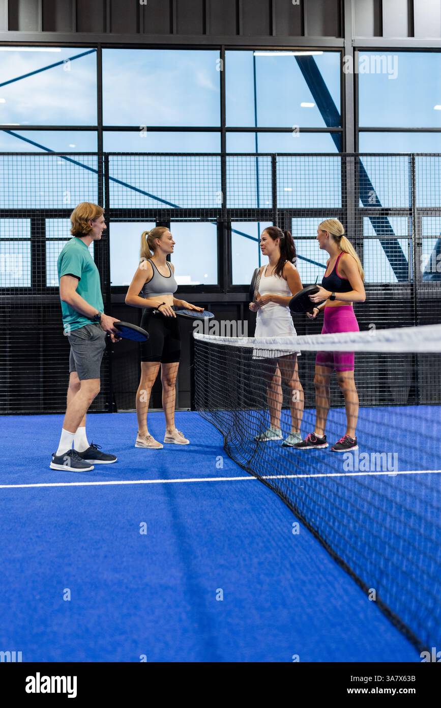 Group of friends discussing strategy on indoor padel tennis court Stock ...
