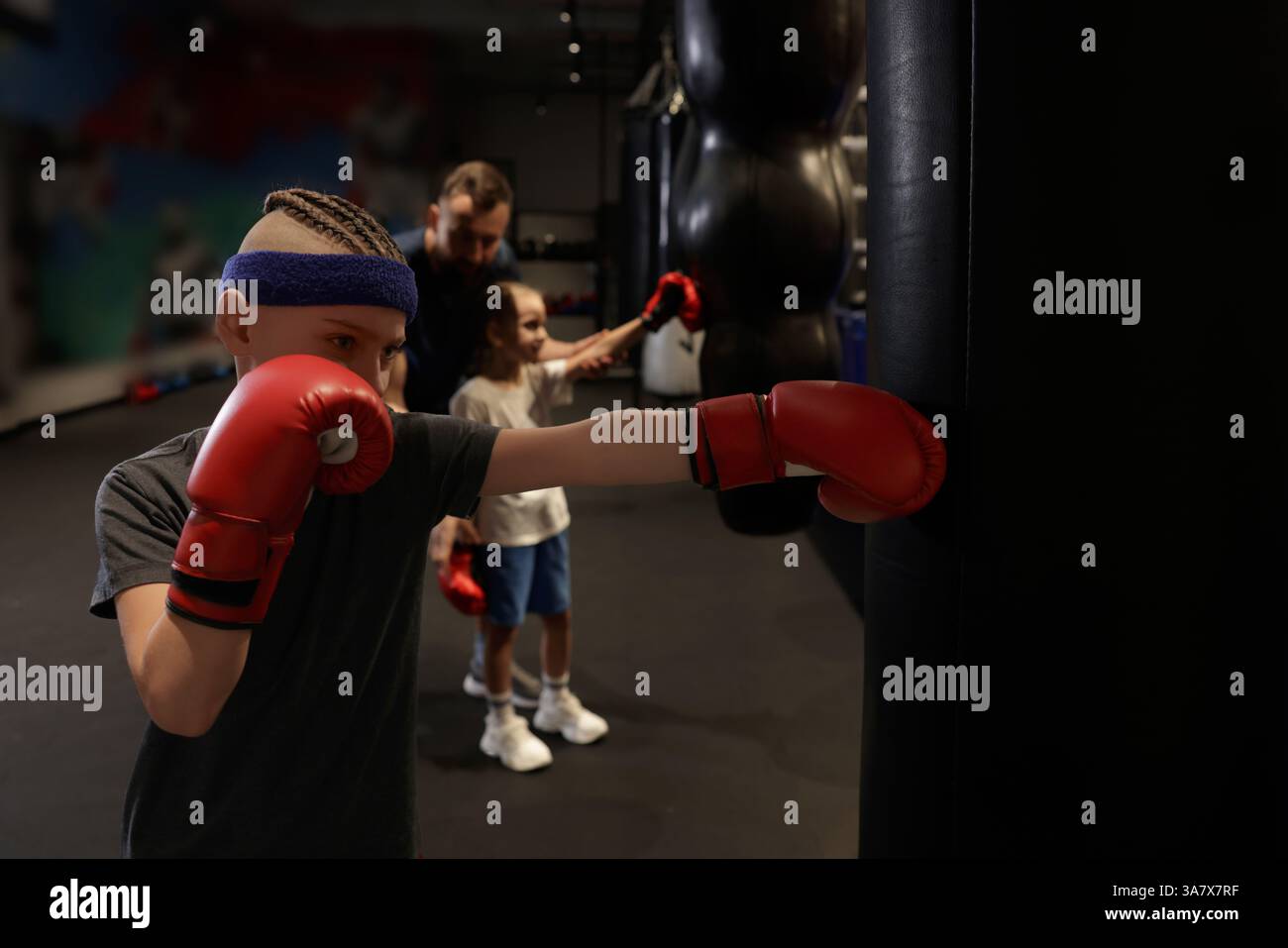 Children having boxing practice with their coach in training center ...