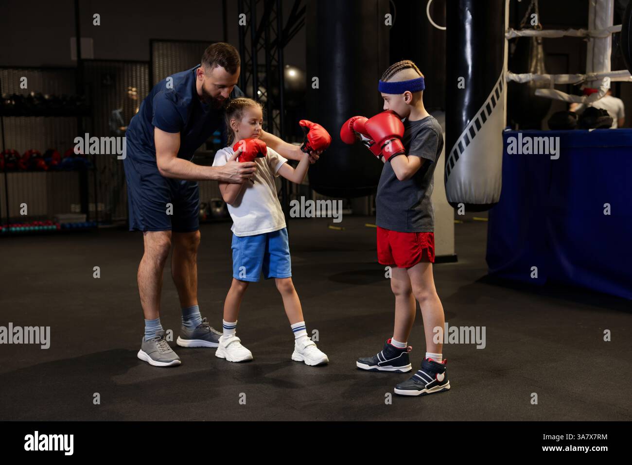 Boxing coach training children in sport center Stock Photo - Alamy
