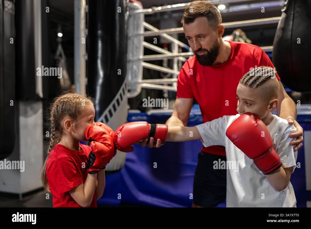 Boxing coach training children in sport center Stock Photo - Alamy