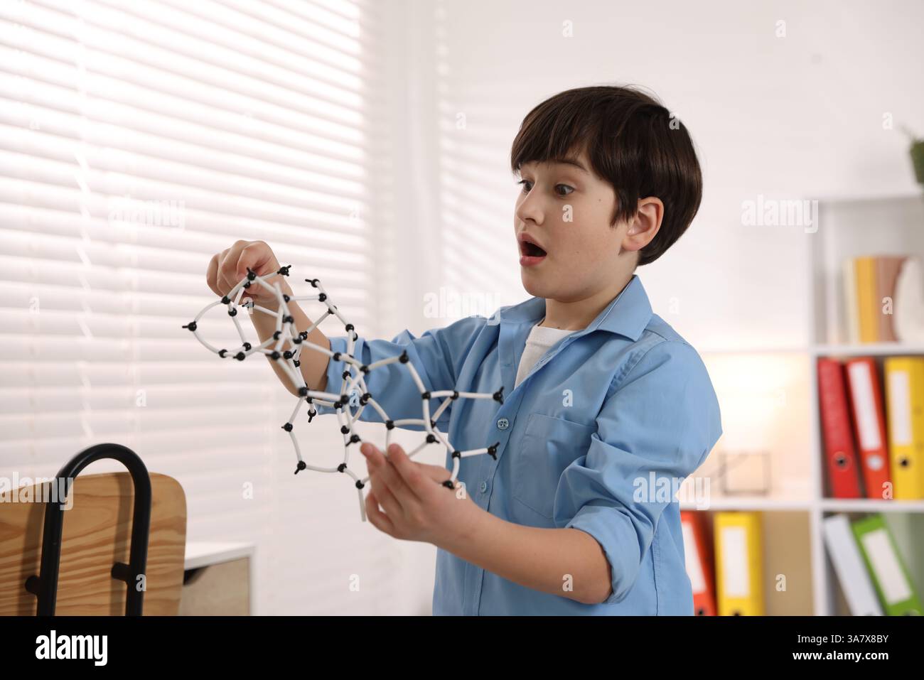 Emotional boy with DNA structure model indoors Stock Photo - Alamy