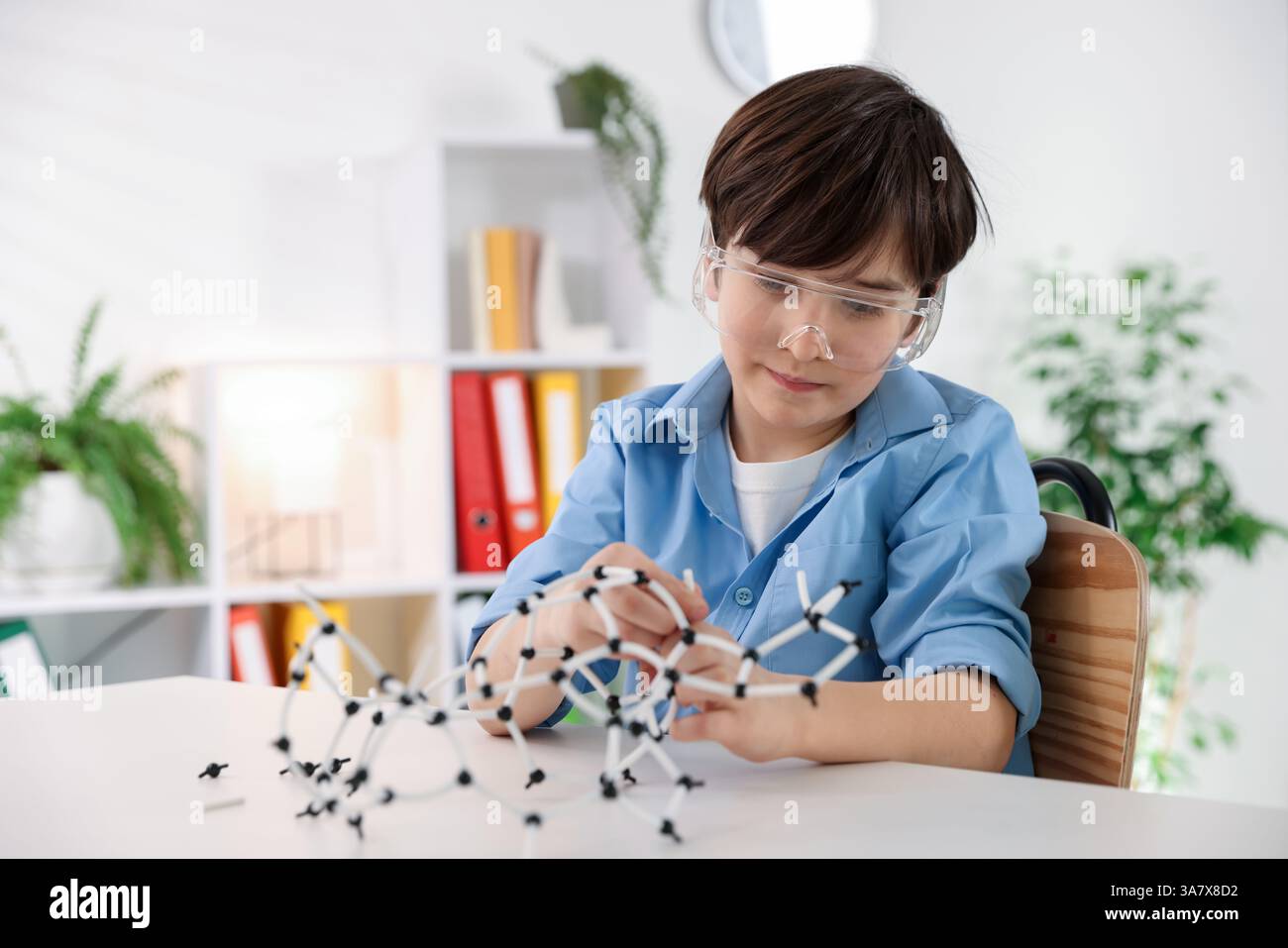 Boy making DNA structure model at desk indoors. Space for text Stock ...