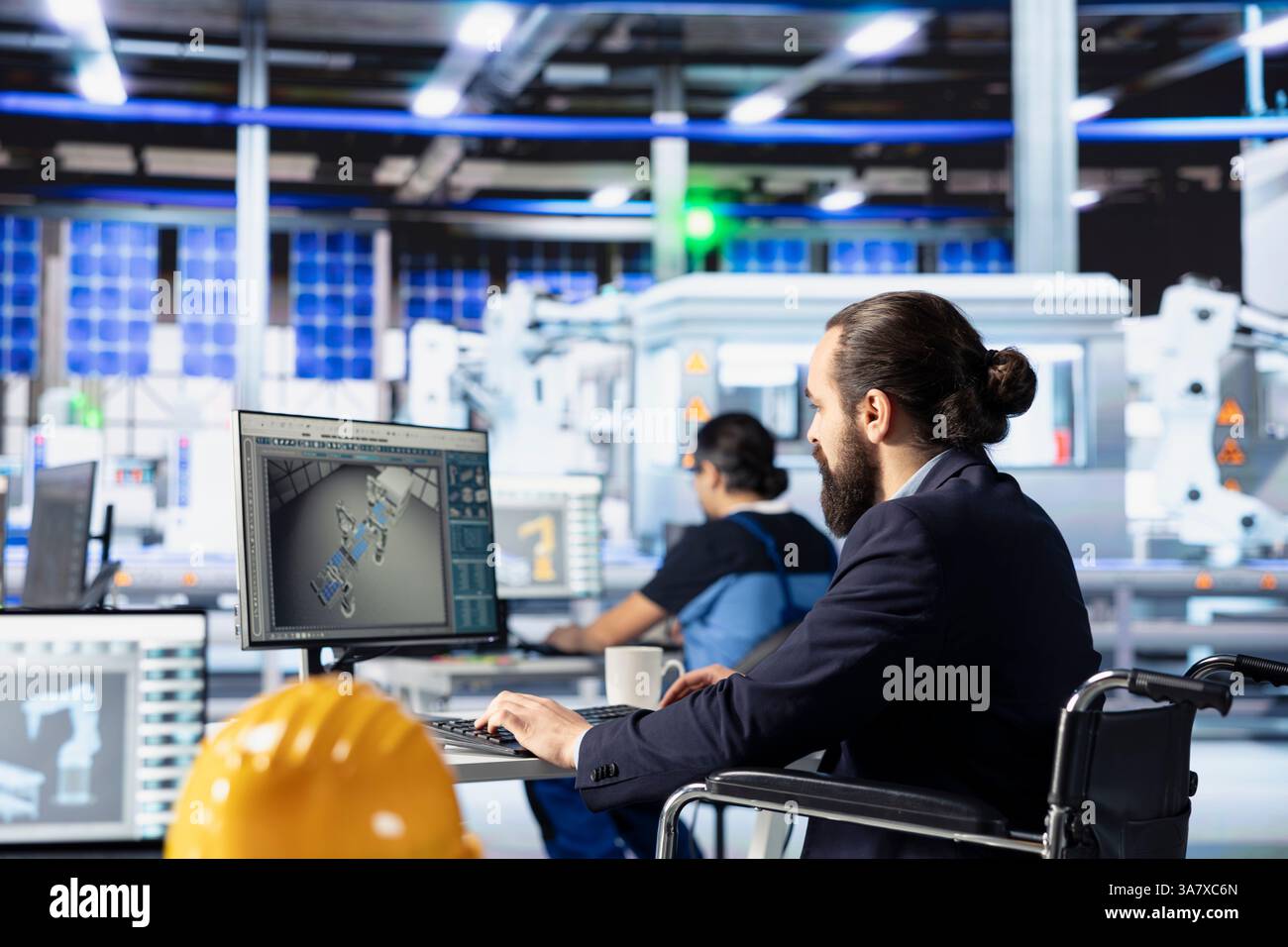 Person with disability in photovoltaics factory working on PC ...