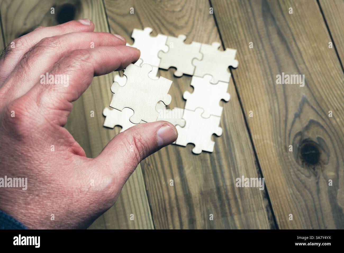 A hand is holding a puzzle piece that is missing. The puzzle is a ...