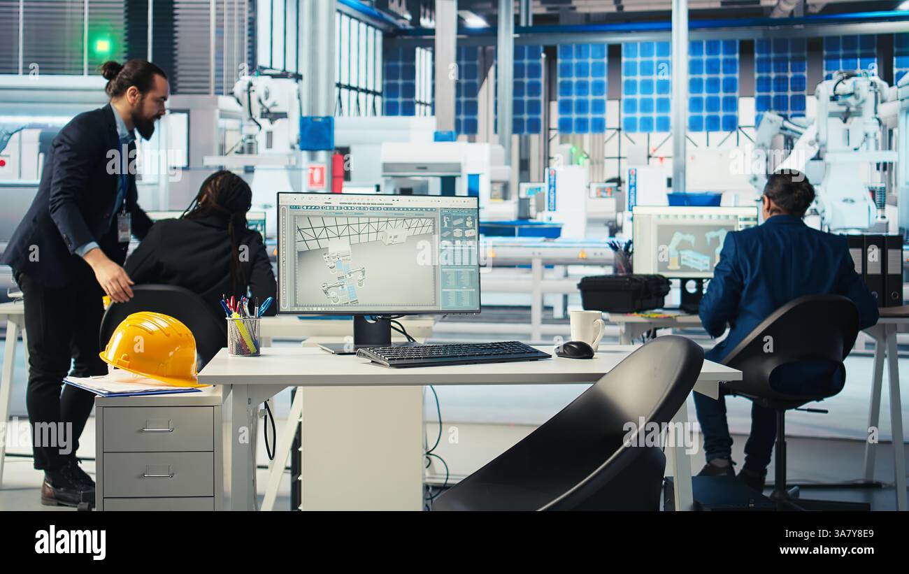 Photovoltaics factory manager walking to employees desks to give tasks ...