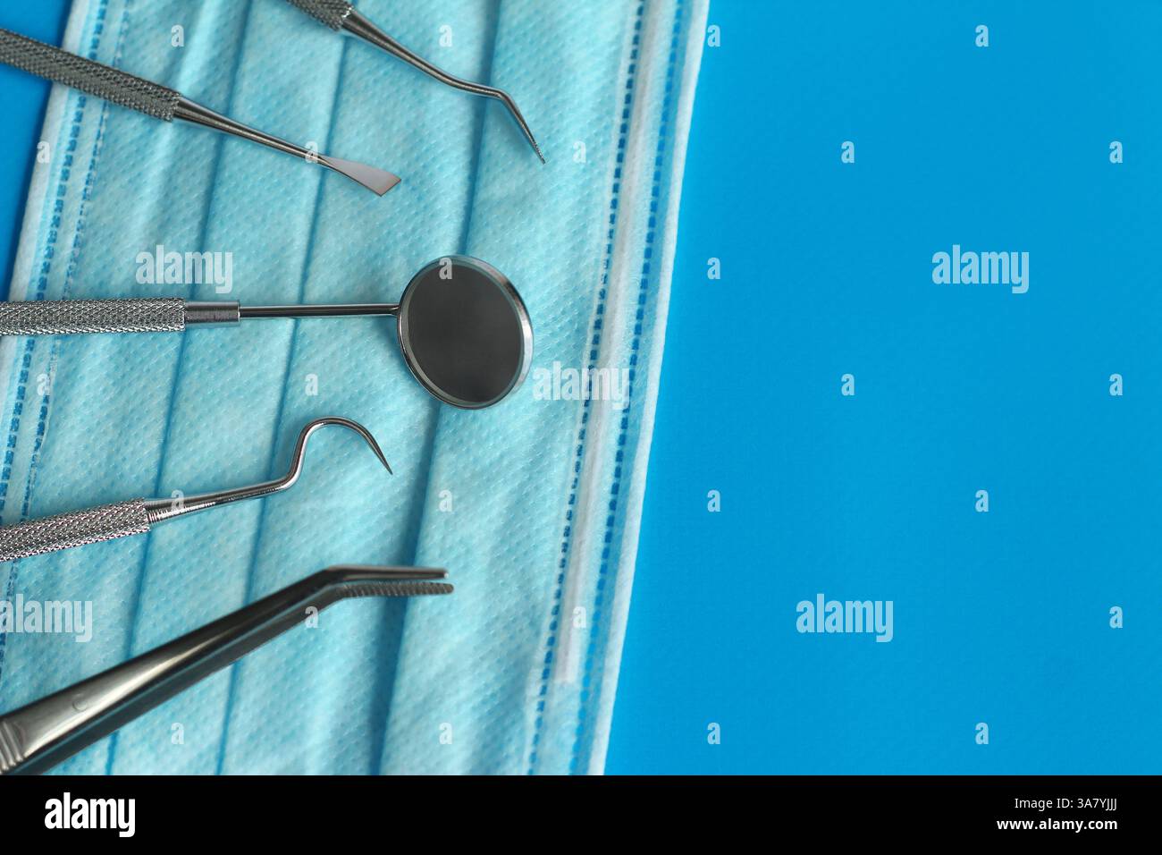 Collection of dental instruments on blue background. Dental mirror ...
