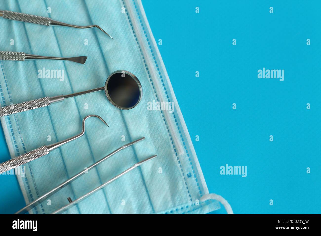 Collection of dental instruments on blue background. Dental mirror ...